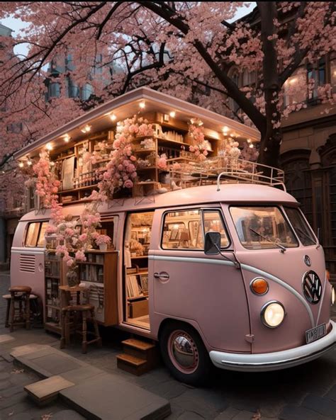 A Pink Vw Bus Parked In Front Of A Building With Bookshelves On The Roof
