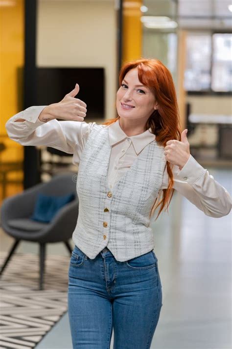 Enthusiastic Redhead With Double Thumbs Up In Office Stock Image