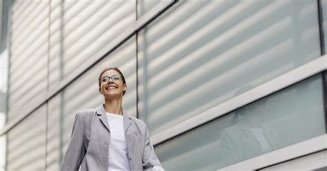얼굴에 미소를 띤 행복한 젊은 사업가가 밖으로 걸어가고 있다 사무실로 가는 사업가 사진 Unsplash의 서비스 이미지