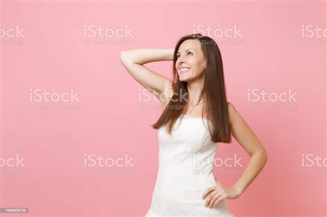 우아한 하얀 웨딩 드레스 서 고 핑크 파스텔 배경에 고립 된 머리 근처에 손을 유지 즐거운 꿈꾸는 신부 여자의 초상화 결혼식 축 하 개념입니다 광고에 대 한 공간을 복사