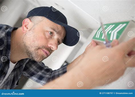Man Fixing Illuminated Exit Sign To Wall Stock Image Image Of Contractor Regulations 271108797
