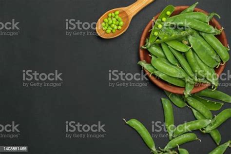 그릇에 깍지가있는 신선한 녹색 완두콩과 검은 색 배경에 숟가락 건강한 식생활에 대한 스톡 사진 및 기타 이미지 건강한 식생활 검은색 계절 Istock