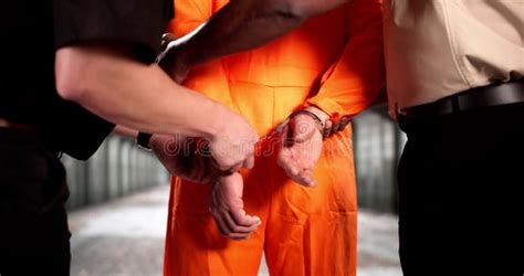 Man In Orange Uniform And Handcuffs In Jail Cell Stock Image Image Of