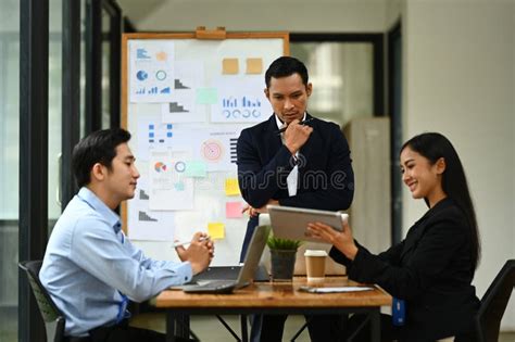 Corporate Team Analyzing Financial Data And Planning Marketing Strategy At Meeting Stock Image