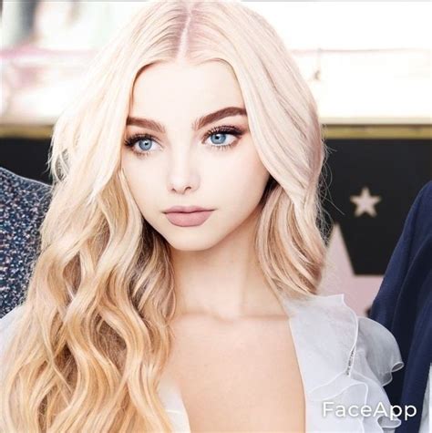 A Woman With Blonde Hair And Blue Eyes Is Posing For A Photo In Front Of A Man