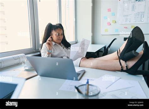 Experienced Female Engineer Examining Technical Documentation In