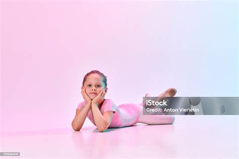 발레 수영복을 입고 네온 불빛이 섞인 손에 머리를 얹고 바닥에 누워 있는 작고 귀여운 발레리나 댄서 소녀의 초상화 6 7 살에 대한 스톡 사진 및 기타 이미지 Istock