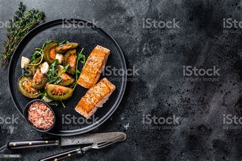 구운 연어 필레 스테이크와 아루굴라 토마토 샐러드를 접시에 얹은 생선 식사 검은 색 배경 맨 위 보기입니다 복사 공간 0명에 대한 스톡 사진 및 기타 이미지 Istock