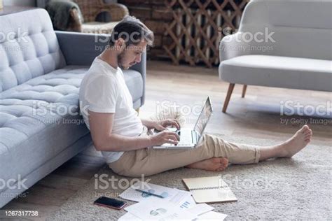 집에서 일기와 공식 논문으로 바닥에 앉아있는 노트북 컴퓨터에서 일하는 남자 가정 생활에 대한 스톡 사진 및 기타 이미지 가정 생활 금융 남성 Istock