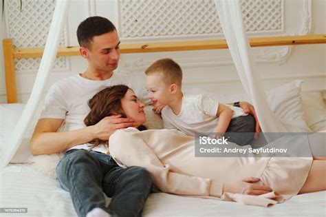 행복한 임신 한 엄마 아빠와 아들은 침대에서 놀고 있습니다 가족 행복의 개념 3 명에 대한 스톡 사진 및 기타 이미지 3 명