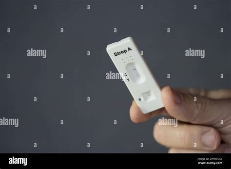 A Close Up Of Hand Holding Positive Streptococcus Test During Infection Diagnostic Test Done At