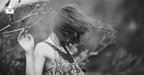 Foto Una Mujer Parada En Un Campo Con El Pelo Soplando En El Viento Imagen Gris Gratis En Unsplash