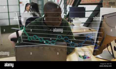 Image Of Graph Over African American Man Working On Computer In Office
