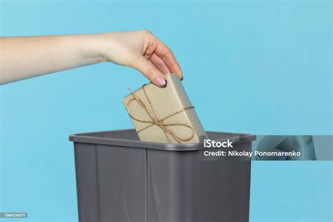쓰레기통에 선물을 던져 쓰레기통 앞에 선물 상자를 손에 넣을 수 있습니다 선물에 대한 스톡 사진 및 기타 이미지 선물 개념