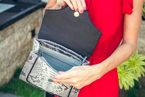 Premium Photo Girl Holding A Bag Made Of Exotic Python Skin Against A