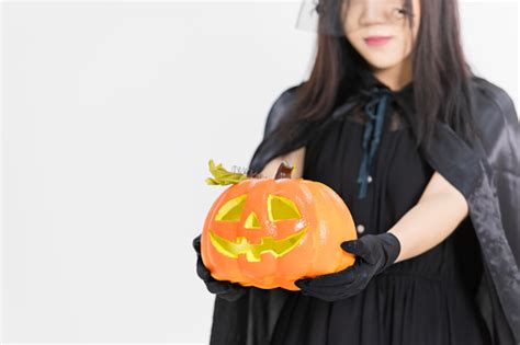 스튜디오 화이트 Backgroung 할로윈 패션 축제에 대 한 개념에 호박 오렌지 할로윈 Jacko를 들고 손으로 메쉬 모자에 검은 마녀에 젊은 아시아 여성 의상을 총 10