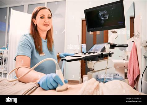Woman Sonographer In Sterile Gloves Examining Patient With Ultrasound