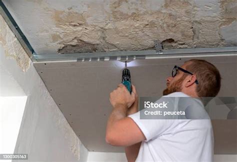 건설 노동자는 드라이월a와 함께 천장을 조립 D는 드라이버와 천장 금속 프레임에 건식 벽을 고정 개선에 대한 스톡 사진 및 기타 이미지 Istock