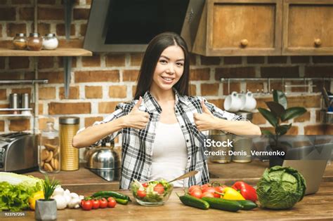 책상 웃 고 근처에 서 있는 젊은 요리 여자 엄지손가락을 나타나 카메라를 보고 가정 생활에 대한 스톡 사진 및 기타 이미지 가정 생활 가정 주방 가정의 방 Istock