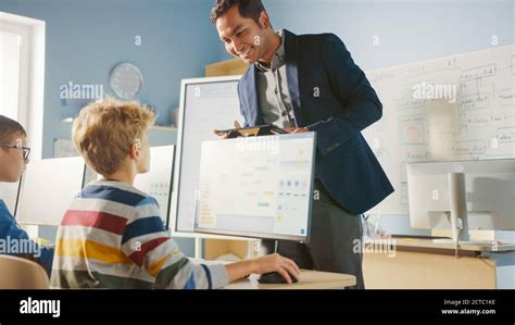 Elementary School Computer Science Classroom Teacher Uses Tablet