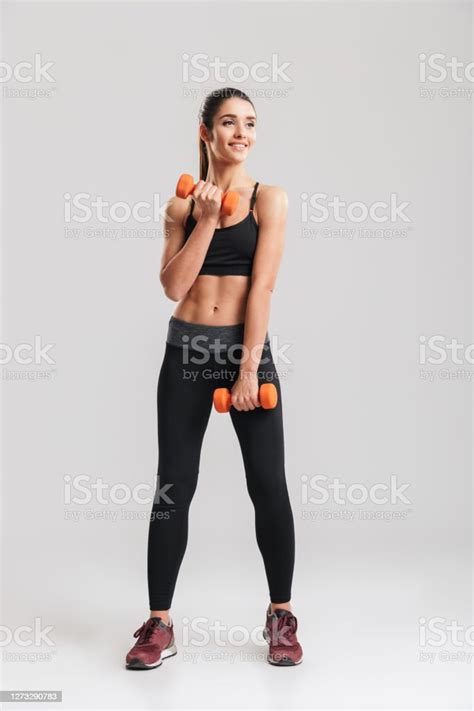 회색 배경에 고립 된 작은 아령과 체육관에서 훈련 스포티 한 슬림 여성의 전체 길이 사진 강사에 대한 스톡 사진 및 기타 이미지 강사 건강한 생활방식 긴 Istock