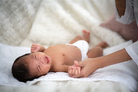 갓 태어난 아기의 손가락을 잡고 있는 아시아 부모의 손 새로 태어난 아기를 안고 있는 어머니의 손을 닫습니다 가족 건강 관리 및 의료 사랑 사진 Unsplash의