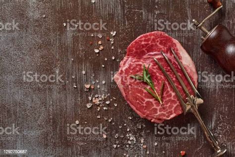 오래된 돌 배경에 소박한 스타일로 소금 후추 로질이 있는 흰 양피지에 신선한 파리지안 생 스테이크 1개 검은 앵거스 맨 위 보기입니다 0명에 대한 스톡 사진 및 기타 이미지