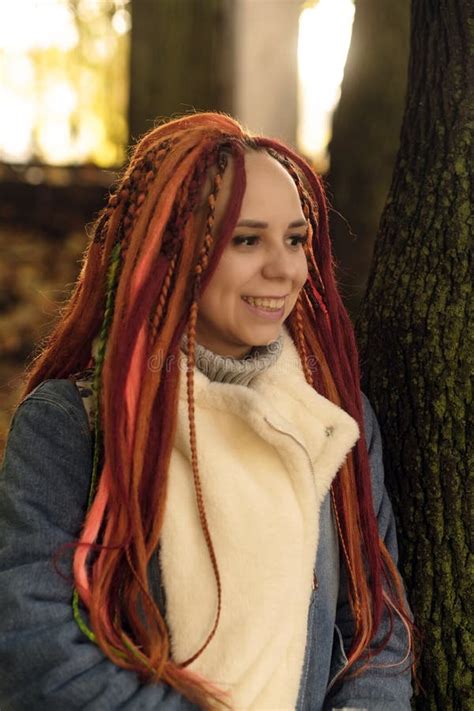 Portrait Of Positive Young Woman With Dreadlocks In Forest Park Pretty