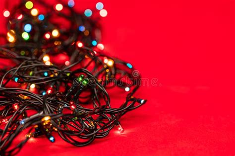 Tangle Of Festive String Lights Glowing In Multiple Colors On A Red