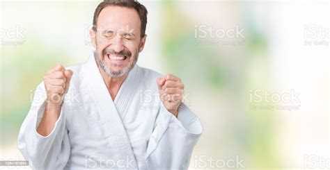 잘생긴 중간 나이 격리 된 배경 위에 균일 한 기모노를 입고 수석 남자 흥분 무기와 성공 위한 축 하 승리 미소 발생 합니다