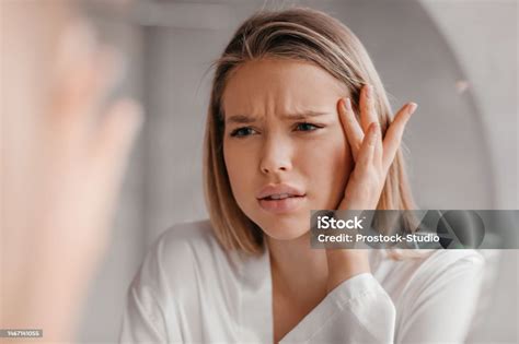 거울을보고 그녀의 이마를 만지고 건조한 피부 문제 첫 번째 주름을 가진 화가 아가씨의 거울 반사 주름에 대한 스톡 사진 및 기타 이미지 Istock