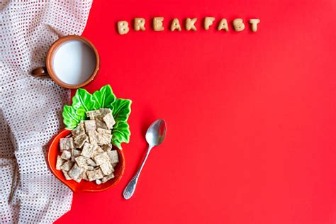 빨간색 배경에 있는 그릇과 우유 컵에서 옥수수 조각 시리얼 아침 식사 콘플레이크 평면도가 있는 그릇 아침 식사를 위한 통 곡물