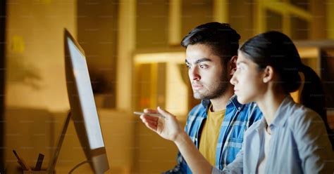 모니터 디스플레이를 가리키고 동료에게 웹 디자인 분야의 초보자를 위한 새로운 온라인 프로젝트 또는 과정을 보여주는 젊은 여성 사진 Unsplash의 설명 이미지