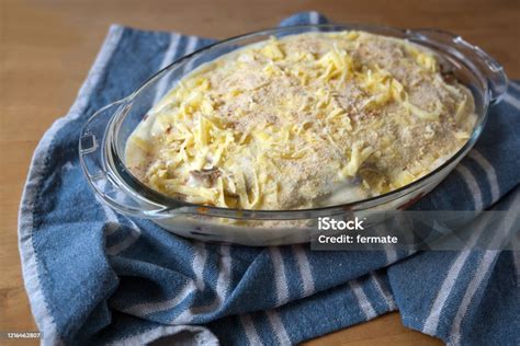 오븐에서 구울 준비가 준비 무사카 가지 감자 다진 고기와 소스의 전통적인 그리스 캐서롤 은 파란색 부엌 수건에 유리 금형에 0