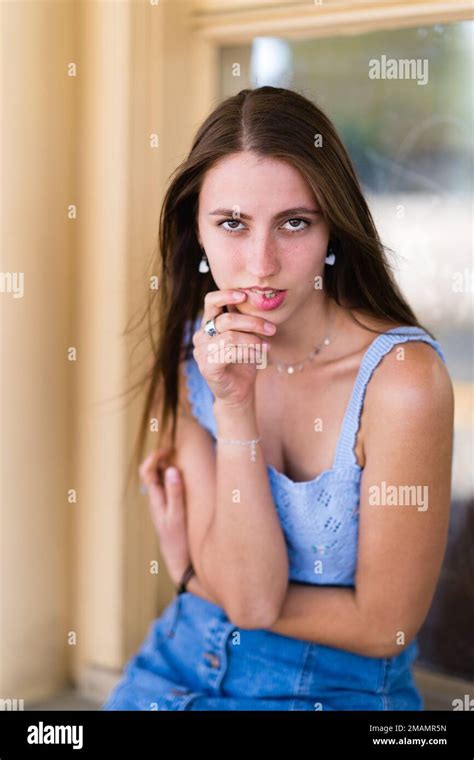 Beautiful Teenage Girl Seated Biting Her Lip Stock Photo Alamy