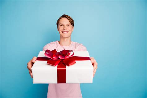 초상화 의 긍정적 인 쾌활한 남자 애인 날짜 와 여자 친구 제공 그녀의 큰 흰색 패키지 선물 상자 착용 캐주얼 스타일 의상 고립 위에 블루 컬러 배경 T 셔츠에 대한 스톡