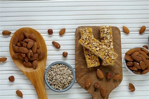Muesli 바 고의 재료입니다 건강 한 다이어트 음식입니다 Muesli 바 설정 오트밀 아몬드 Hazelnuts과 하얀 나무 바탕에 둥근 클레이 컵에 해바라기 씨 건강
