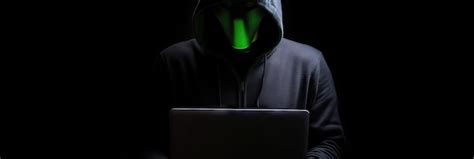 Premium Ai Image Hacker Without Face In A Hood Holds A Laptop On A Background Banner For Cyber