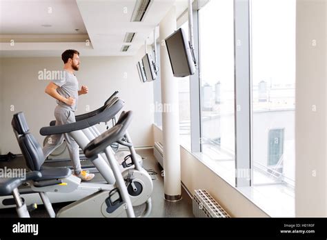 Handsome Man Running On Treadmill In Gym Stock Photo Alamy