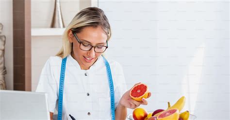 상담실에서 웃고 있는 젊은 여성 영양사의 초상화 건강한 과일 주스 측정 테이프가 있는 영양사 책상 다이어트 계획을 세우는 영양사 사진 Unsplash의 세르비아 이미지