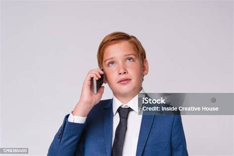 회색 배경을 통해 고립 된 전화로 이야기 하는 빨간 머리와 젊은 백인 소년의 초상화를 닫습니다 10 11세에 대한 스톡 사진 및 기타 이미지 Istock
