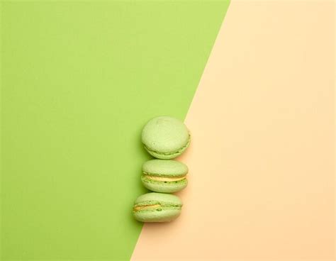 Premium Photo Baked Green Macarons Cookies Lie In A Row On A Green Beige Background Overhead View