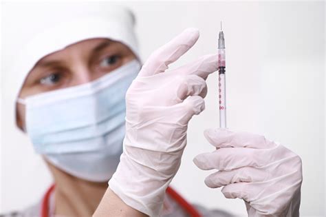 주사기 손에 의료 주사 손바닥 또는 손가락 바늘이있는 의학 플라스틱 예방 접종 장비 간호사 또는 의사 액체 약물 또는 마약 병원의 건강 관리 25 29세에 대한 스톡 사진