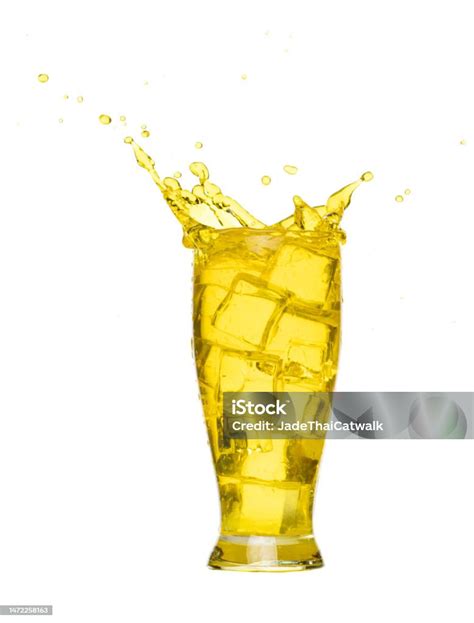 얼음 조각 유리에 라임 주스를 쏟고 라임 주스가 노란색 액체 물에 떨어집니다 주스의 녹색 라임은 공기 중에 튀어 나옵니다 흰색 배경 격리된 고속 셔터 정지 동작 각얼음에