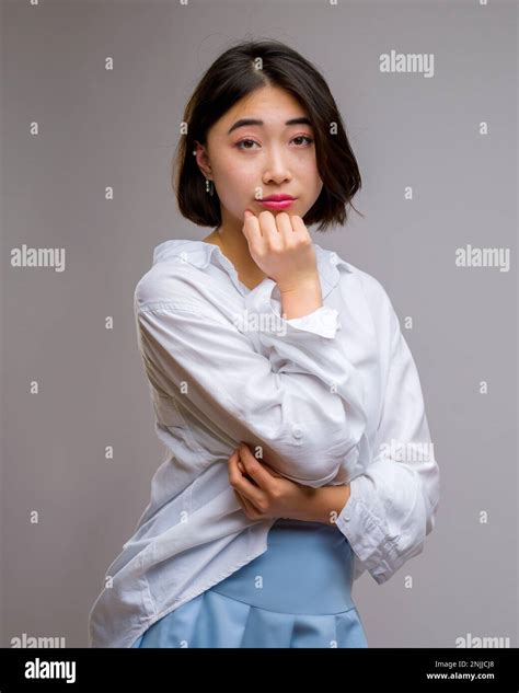 Half Body Portrait Of Young Beautiful Asian Woman Standing In Front Of White Background Arms