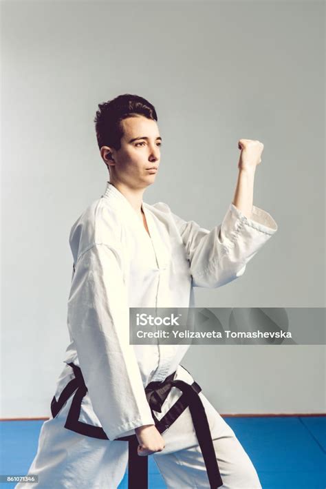 가 라 데에서 여자 기모노 회색 배경에서 스튜디오에 맞게 여자 아이 유도 나 가라테 표시 화이트 블랙 벨트와 유니폼에 슈 탄 스 개별 무술 스포츠입니다 몸 초상화 가라테에