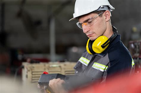 공장에서 자동 로봇 기계를 유지 보수 또는 수리하기 위해 로봇 컨트롤러를 들고 있는 남성 엔지니어 공장에서 제어 자동 로봇 암