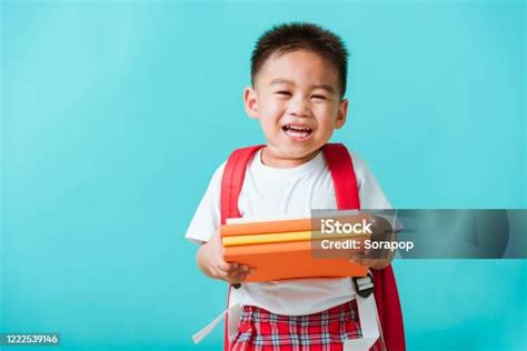 학교로 돌아갑니다 초상화 아시아 행복 재미 귀여운 어린 아이 소년 미소와 웃음 을 들고 책 스튜디오 촬영 고립 된 파란색 배경 유치원에서 아이 와 학교 가방 교육 가방에