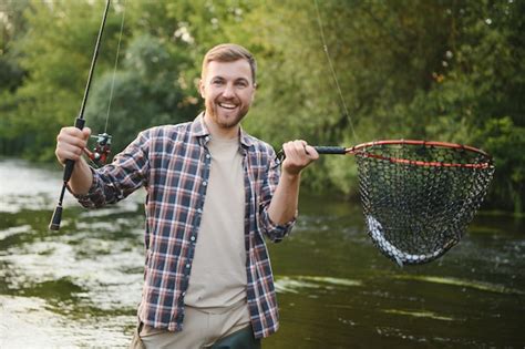 Premium Photo Fisherman Catches A Trout On The River In Summer