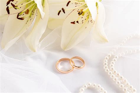 두 개의 금 결혼 반지와 화려한 하얀 백합 머리의 클로즈업 진주 구슬이 있는 새틴 배경 디자인 레이아웃 2명에 대한 스톡 사진 및 기타 이미지 Istock